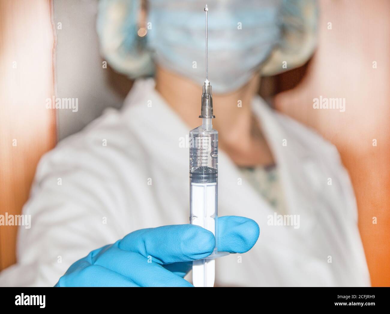 Professional doctor woman with medical syringe in hands, getting ready ...