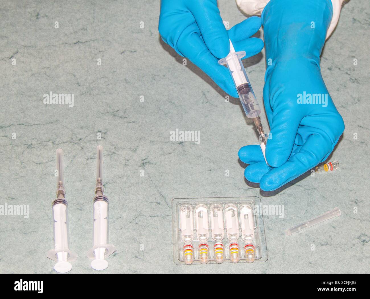 Nurse gaining medication from the vial into the medical syringe for ...