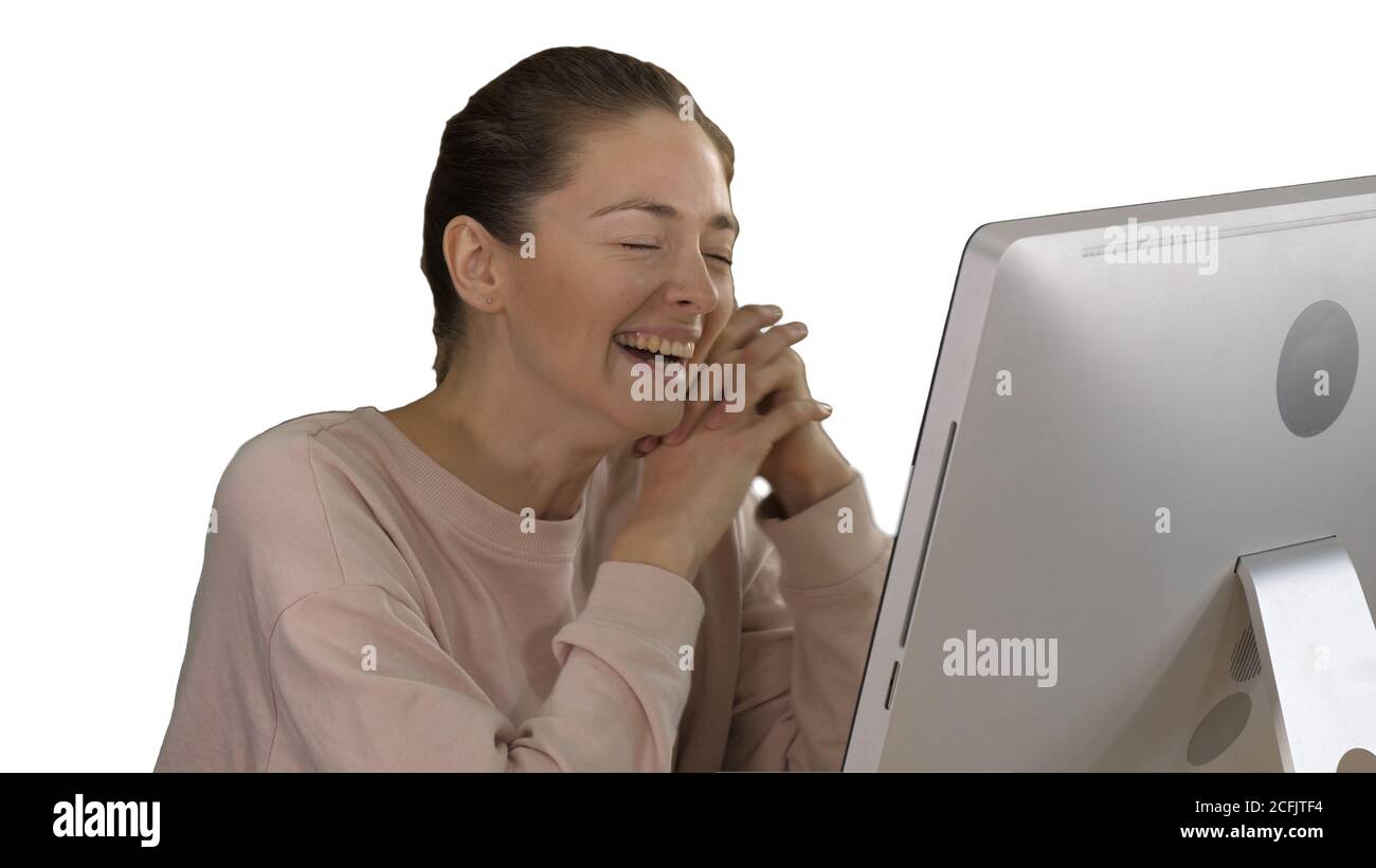 Woman watching videos on computer and laughing on white background ...
