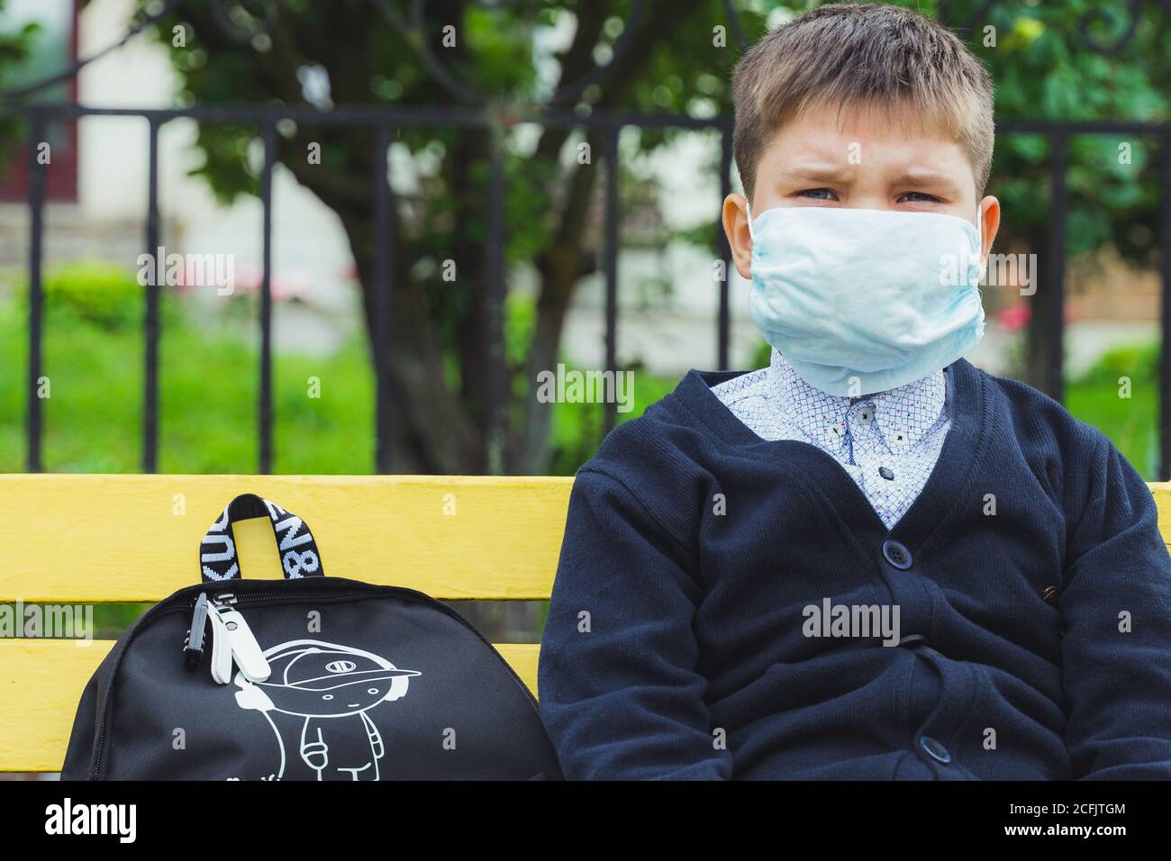 sad kid boy wearing a face mask for coronavirus prevention. Back to ...