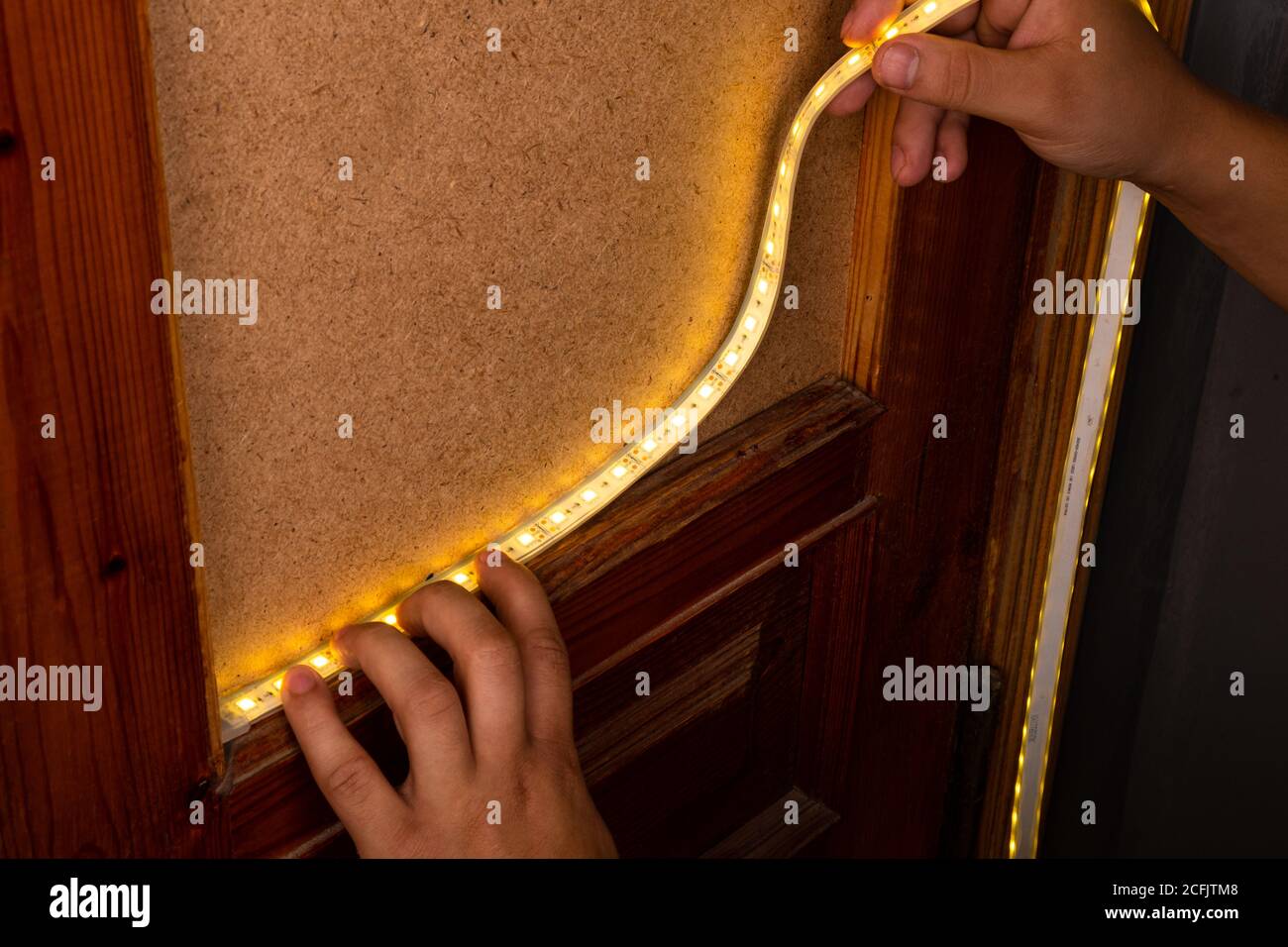 installation of LED strip with warm yellow light on the door for ...