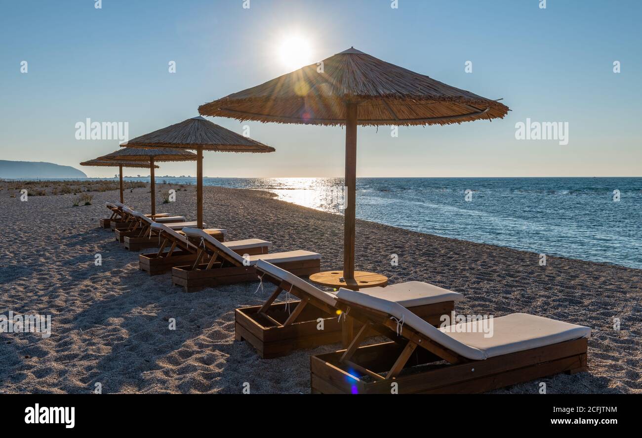 A beautiful deserted long sandy beach in hot summer sun with cloudless ...