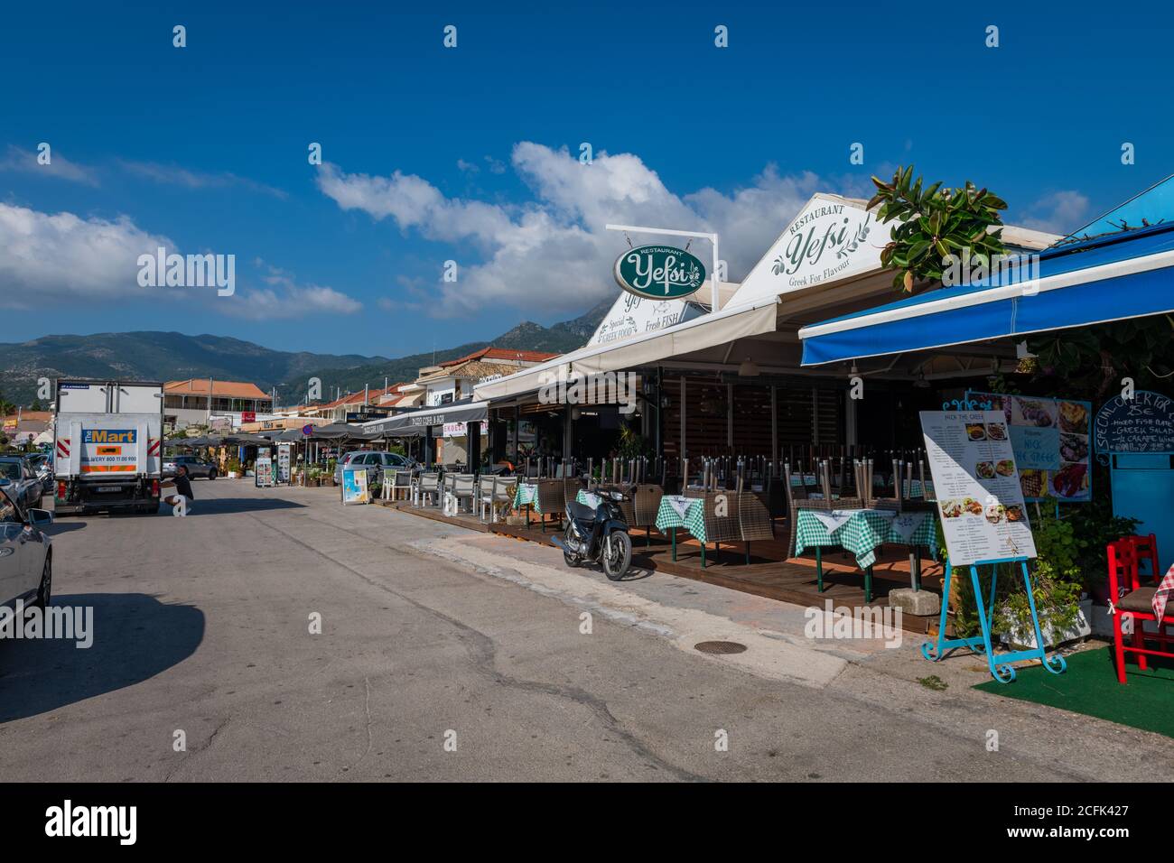The road along the seafront of the holiday resort Nydri, lined with ...