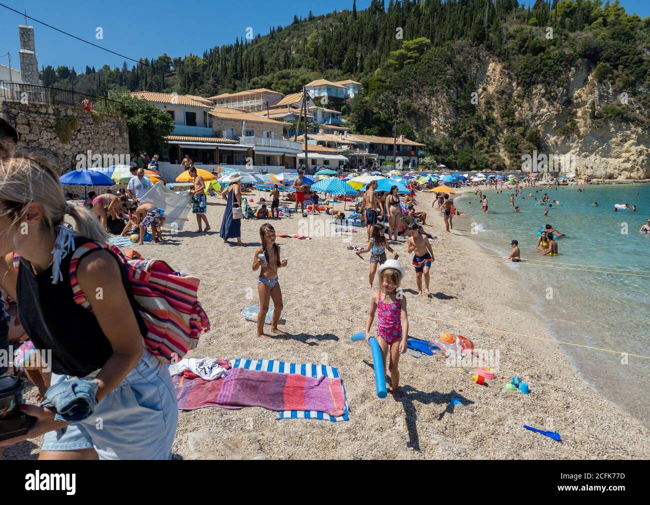 Tourists enjoying a beautiful hot summer day on the beach of this ...