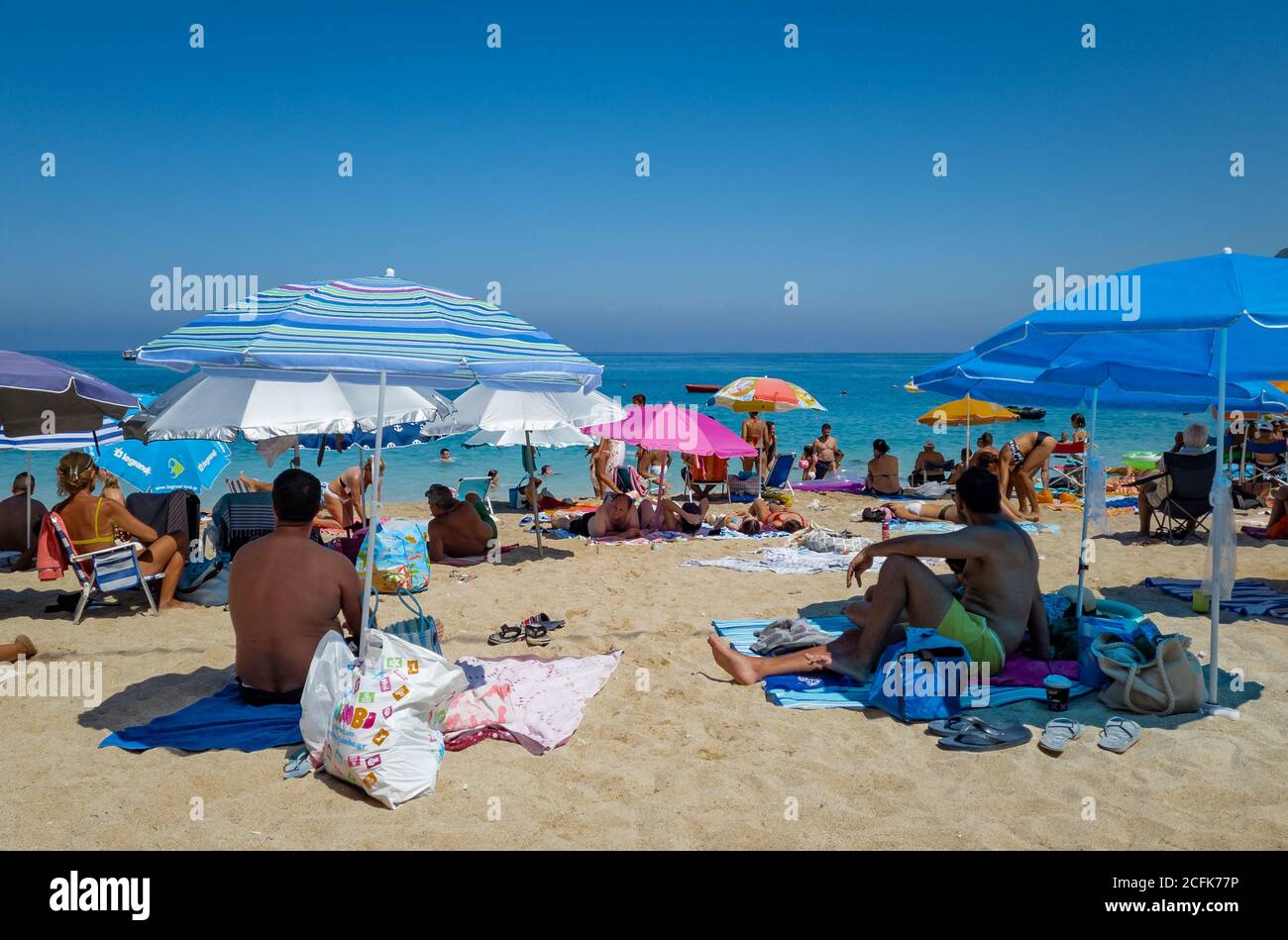 Tourists enjoying a beautiful hot summer day on the beach of this ...