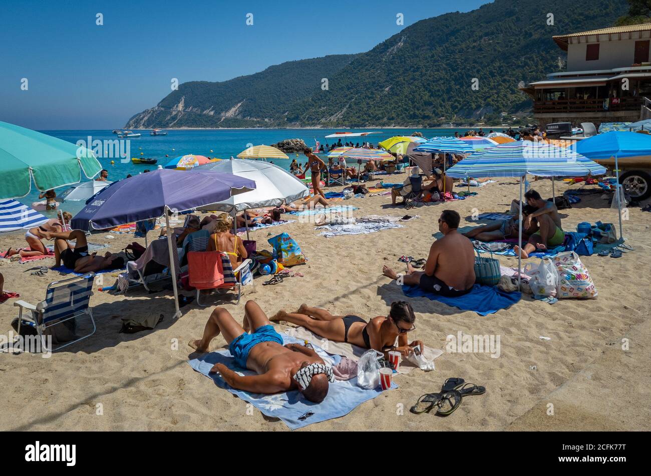 Tourists enjoying a beautiful hot summer day on the beach of this ...