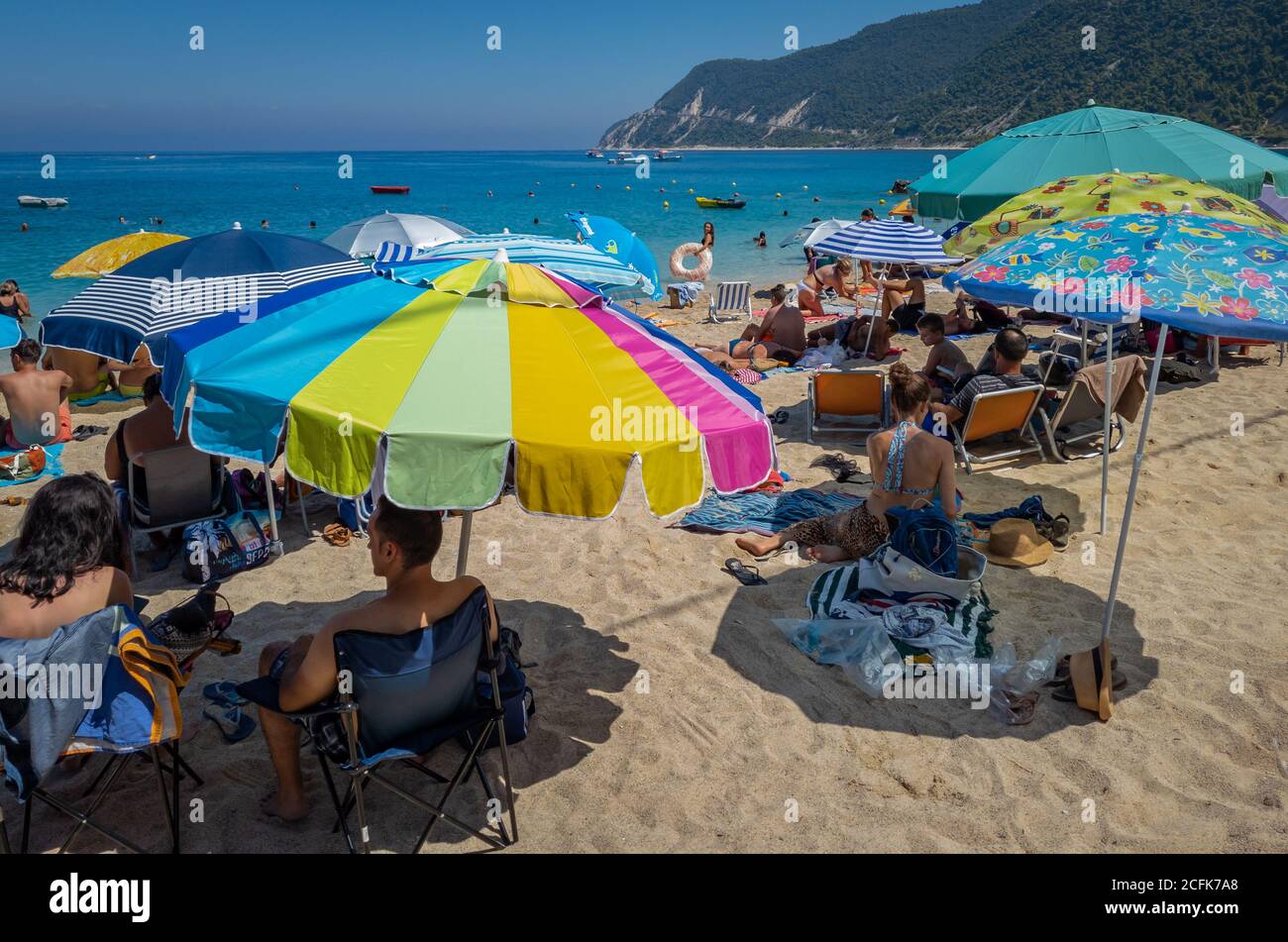 Tourists enjoying a beautiful hot summer day on the beach of this ...