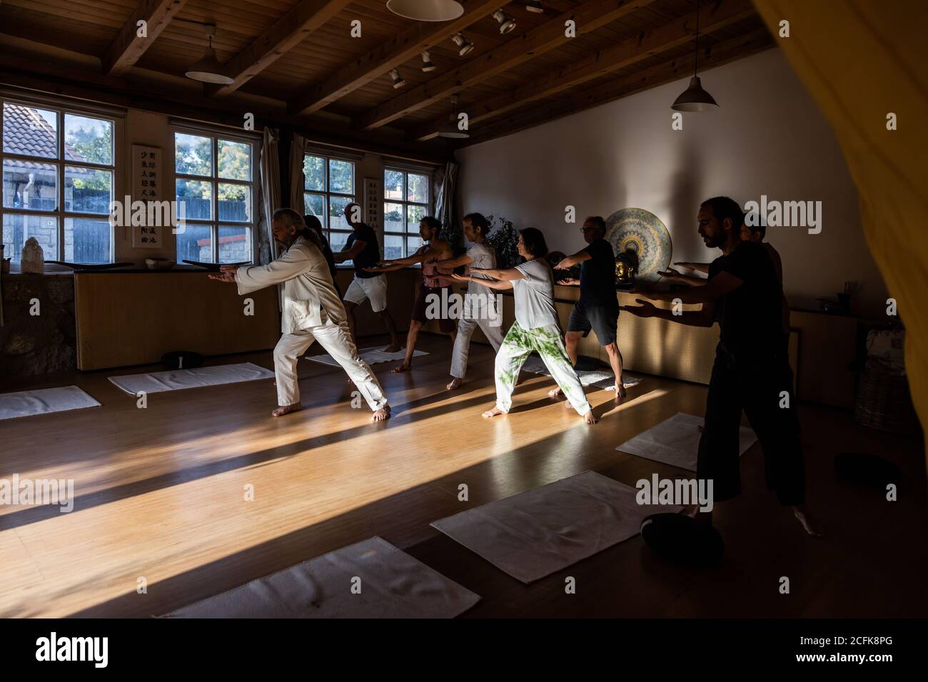 Group of people with instructor performing flowing movements with ...