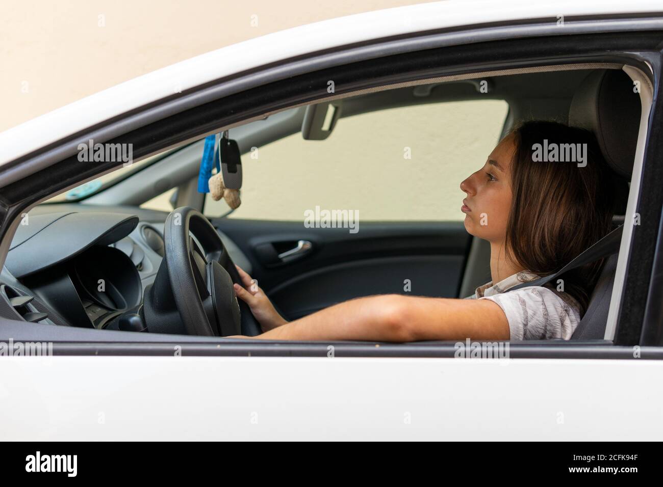 Side view of sad female driver sitting in modern car while stuck in ...