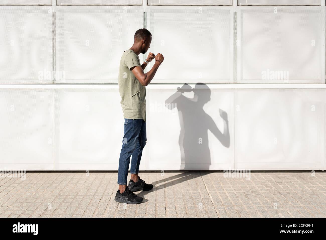 Side view of African American male standing in city in fighting ...