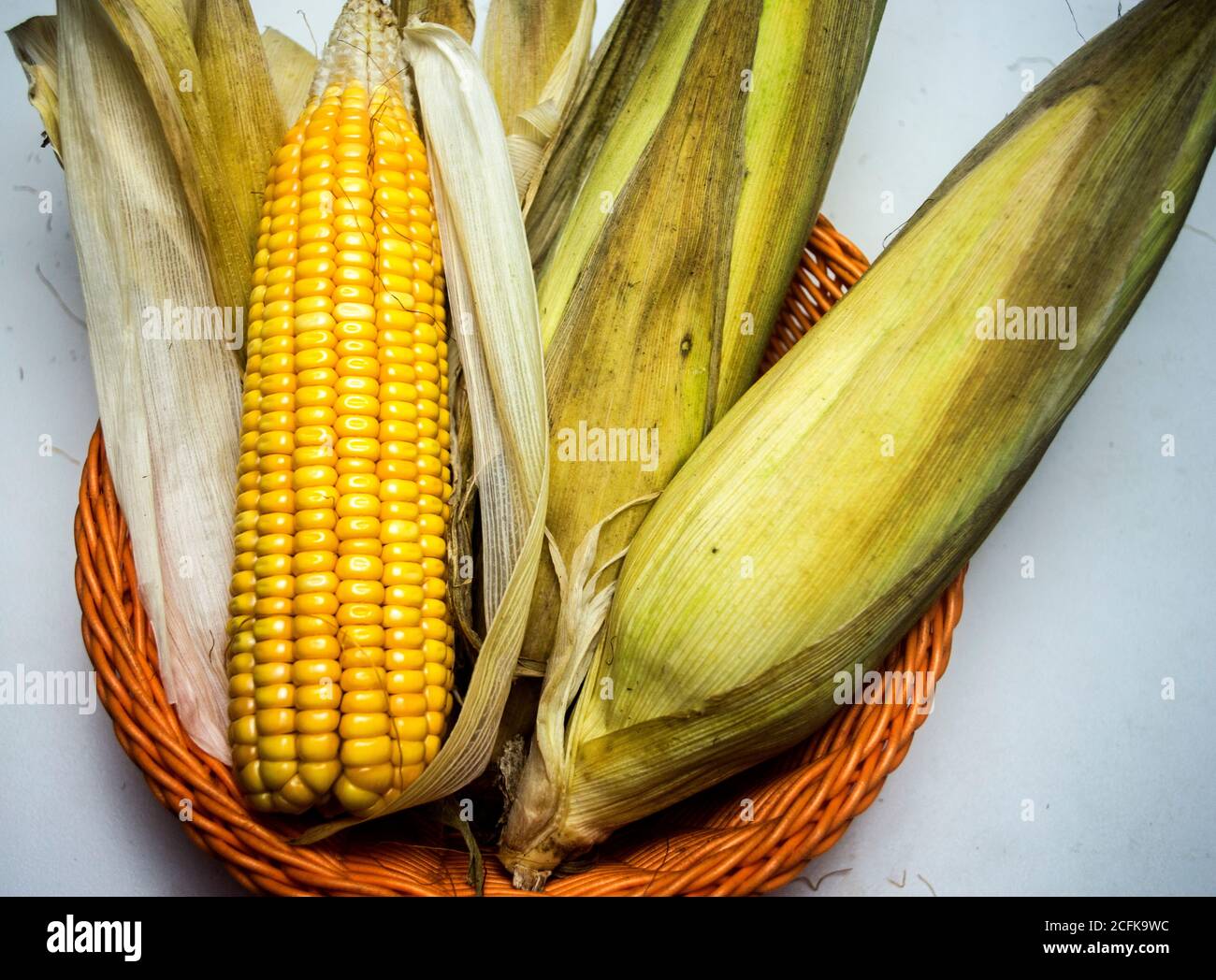 Raw sweet corn on blurred background with dried leaves Stock Photo - Alamy