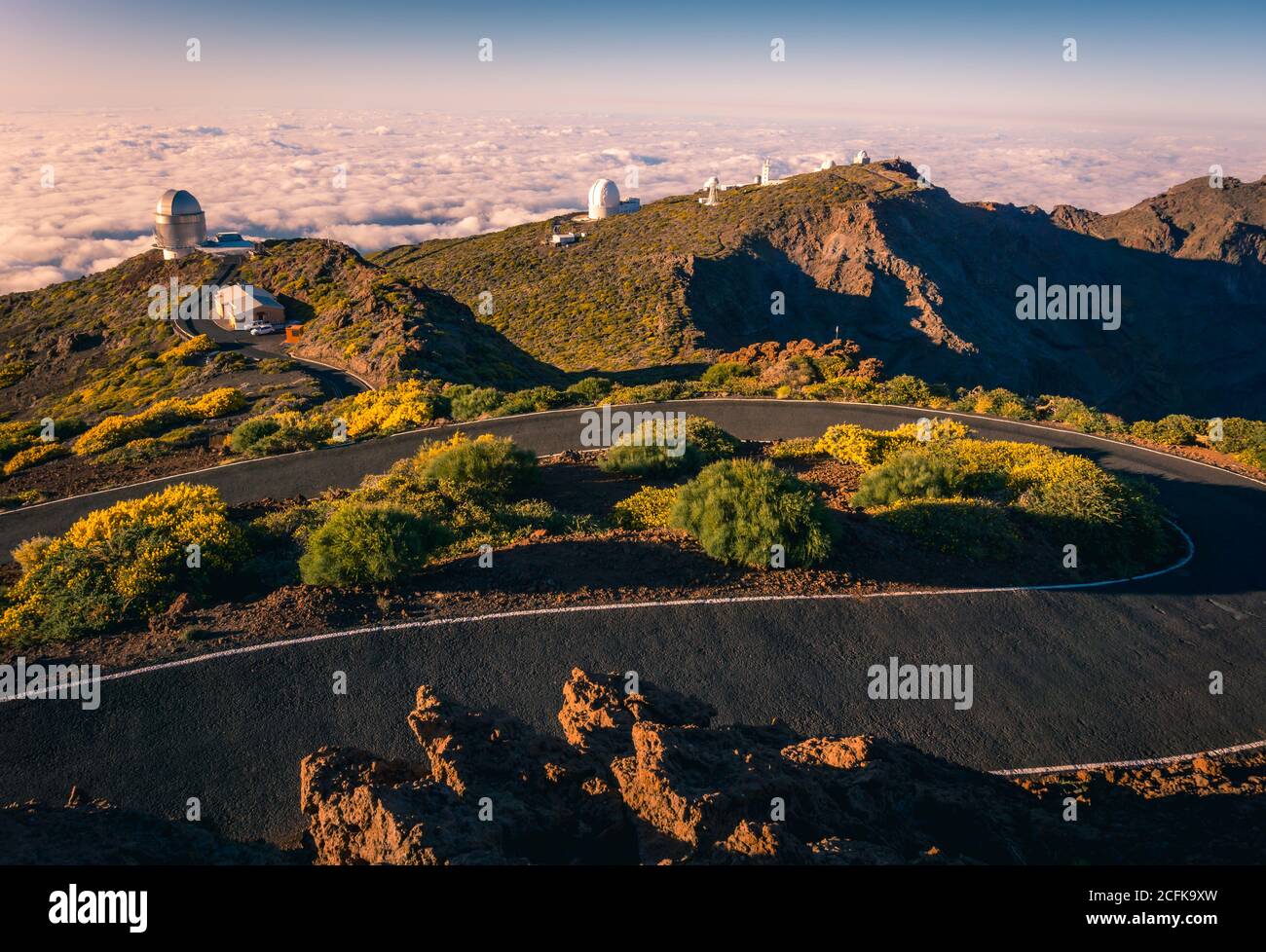 Breathtaking landscape with observatory located on hill above clouds at ...