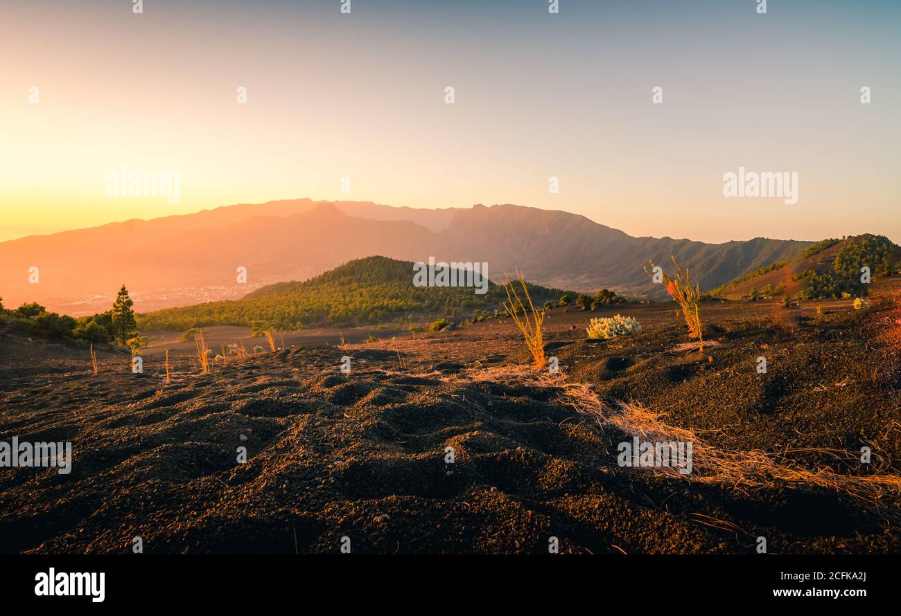 Majestic landscape of mountain range covered with clouds and valley with trees under blue ...