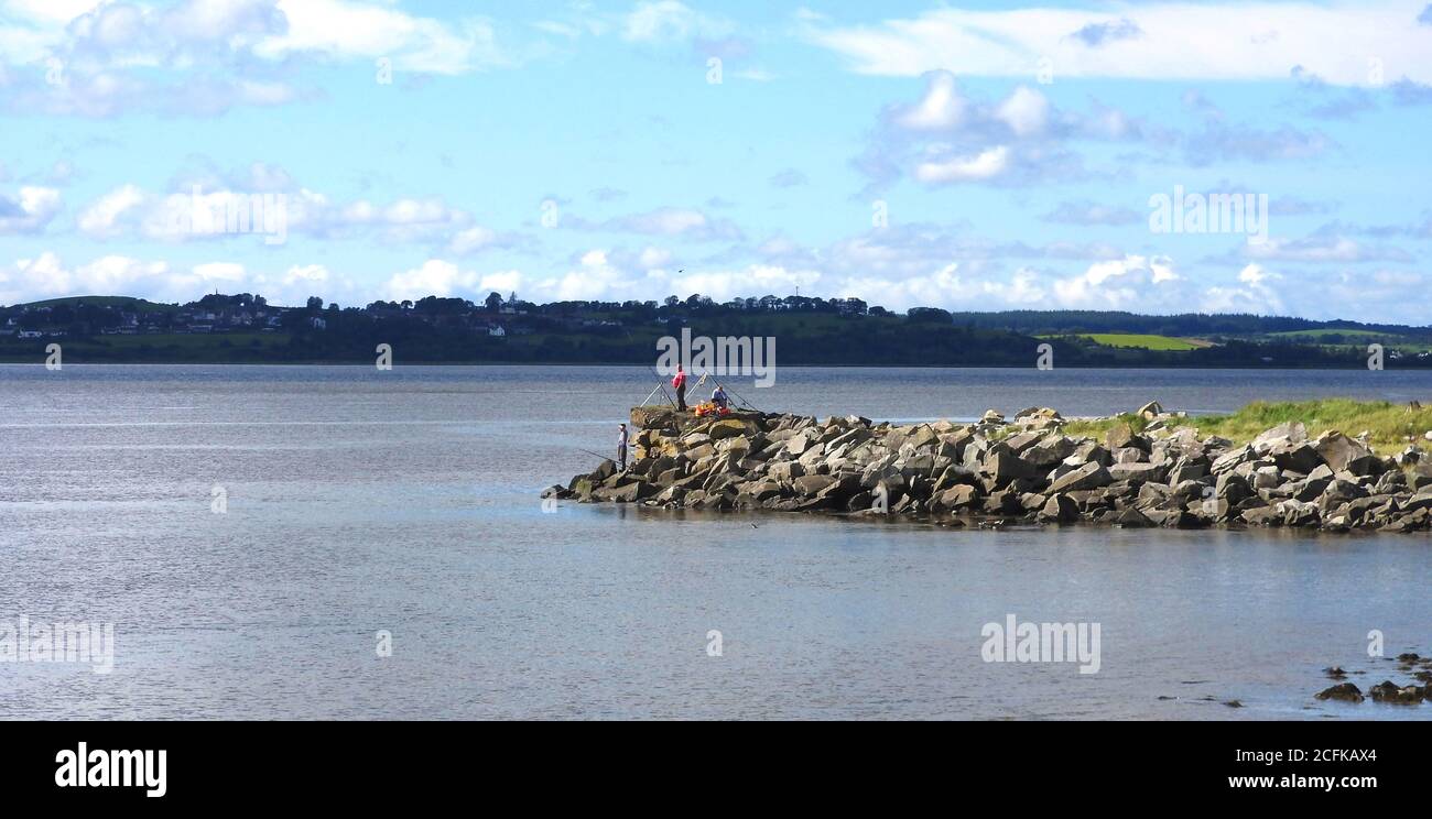 Rod fishermen on a jetty in the River Cree estuary looking from the ...