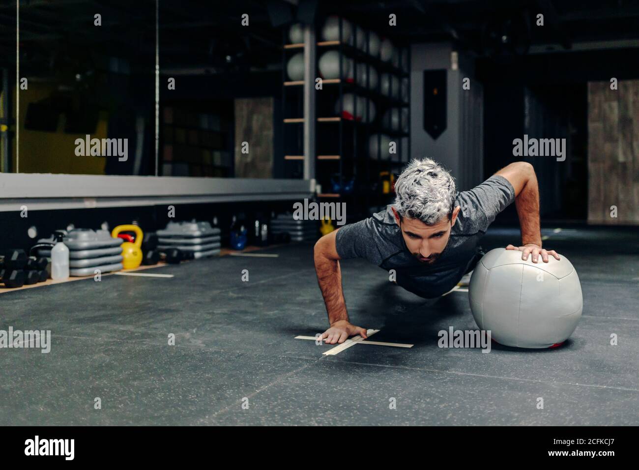 Full length of strong determined athletic male doing plank exercise ...