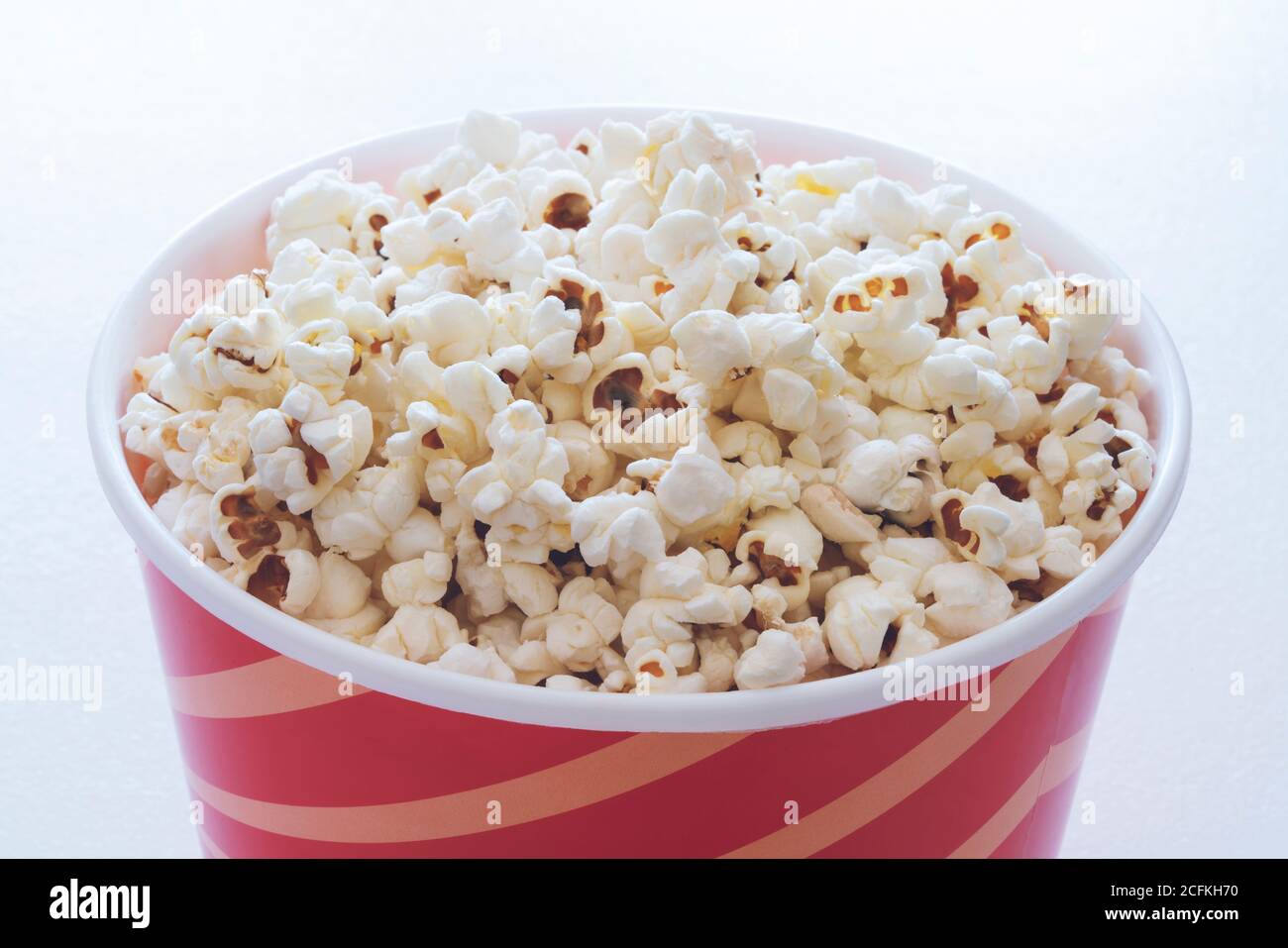 Popcorn in red striped cardboard bucket isolated on white background ...