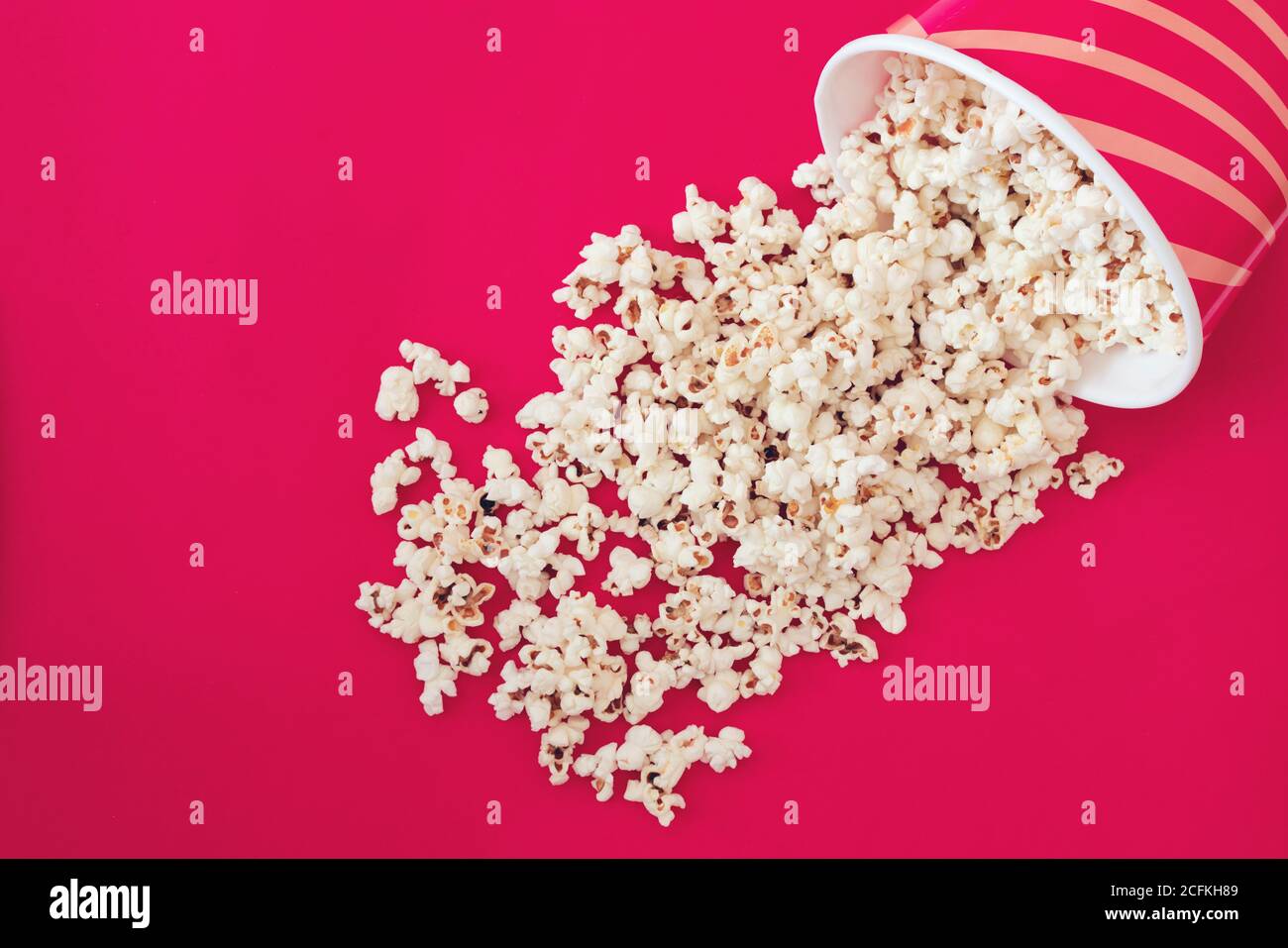 Cup with popcorn on pink color background Stock Photo - Alamy