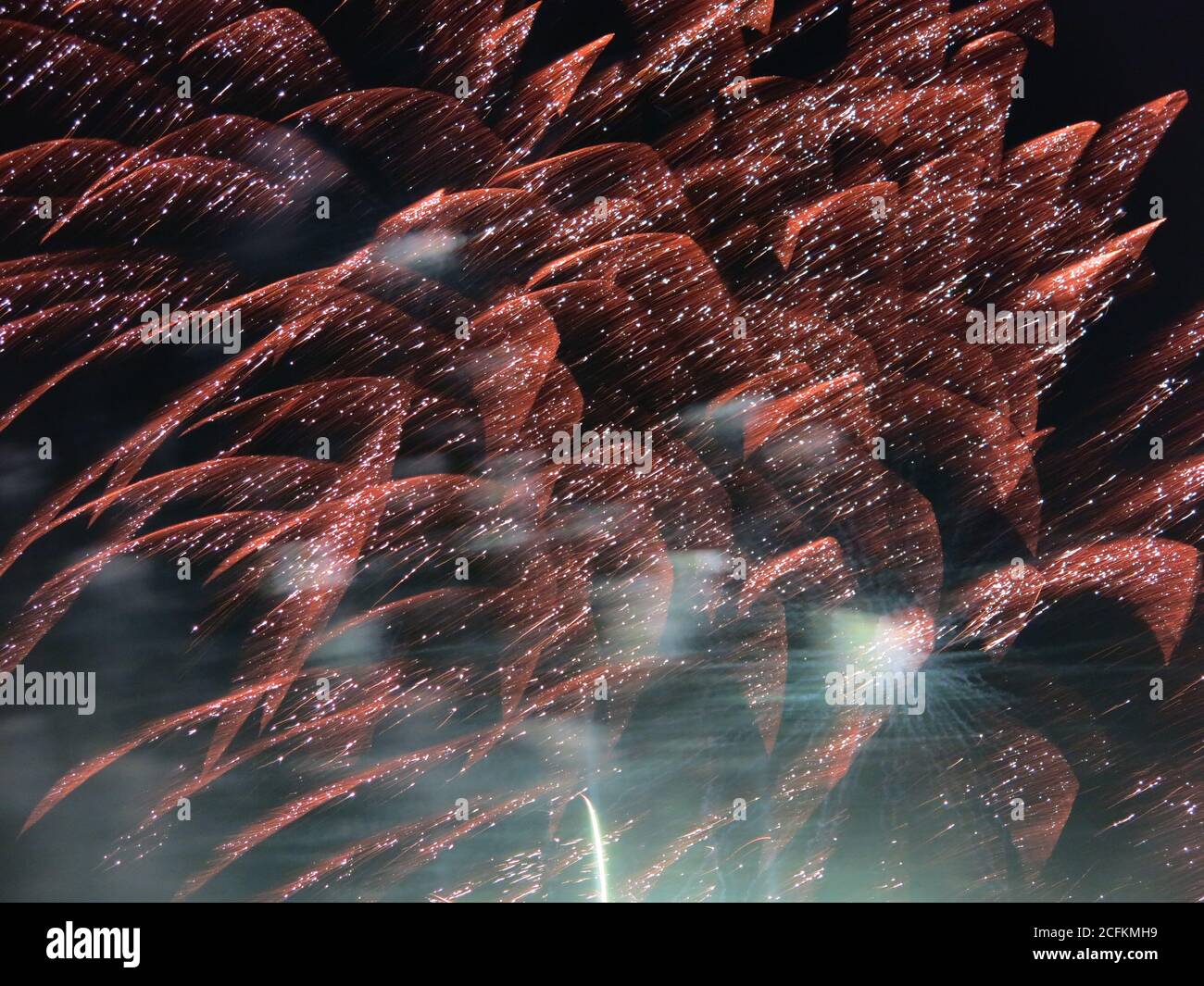 Abstract pattern of red smoke trails in the dark night sky at a ...