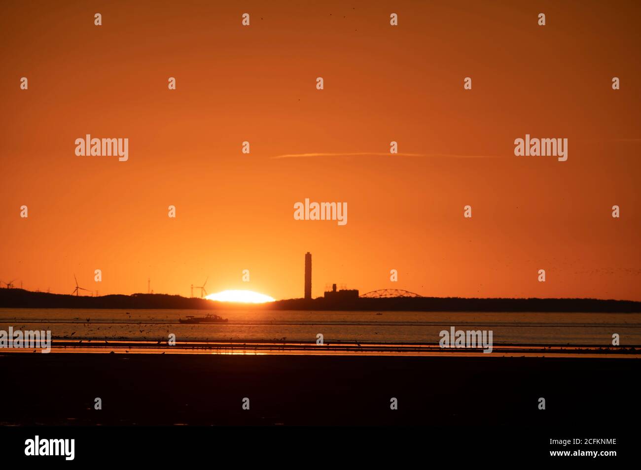 The sun sets behind a power plant on Cape Cod on a summer evening Stock ...