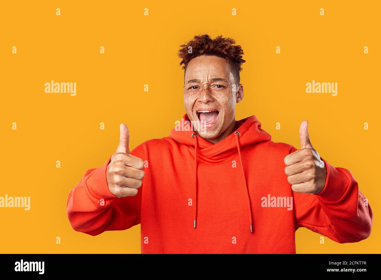 Young adult male showing thumbs up and smiling wide Stock Photo - Alamy