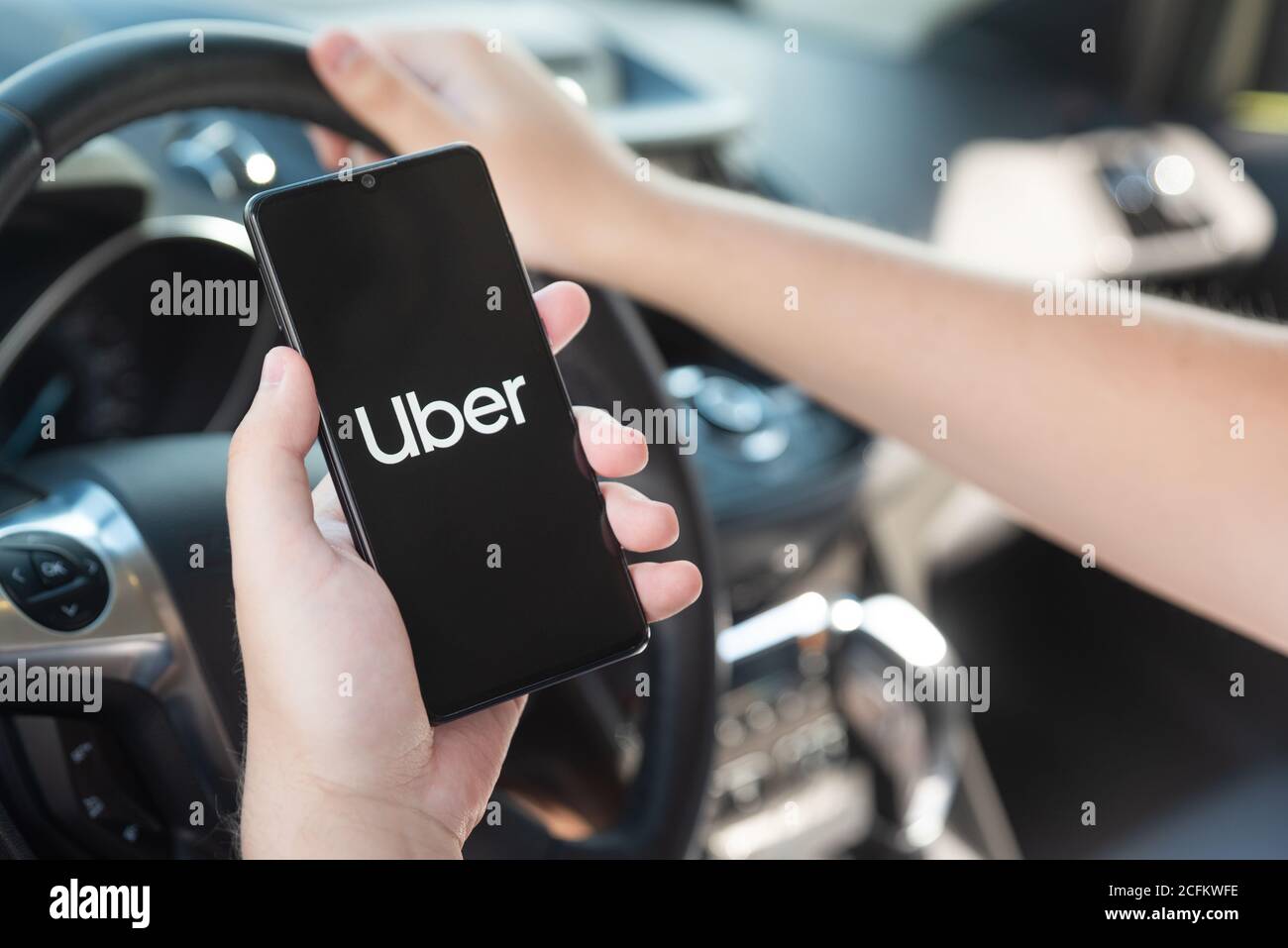 Wroclaw, Poland - AUG 25, 2020: Uber driver holding smartphone in car ...