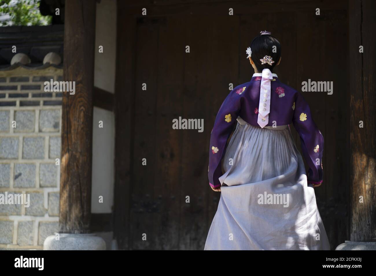Rear view of woman in Hanbok standing at traditional Korean house Stock ...