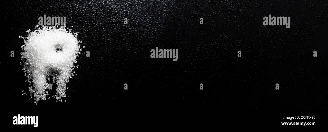 sugar decaying tooth character on a black background top view with copy ...