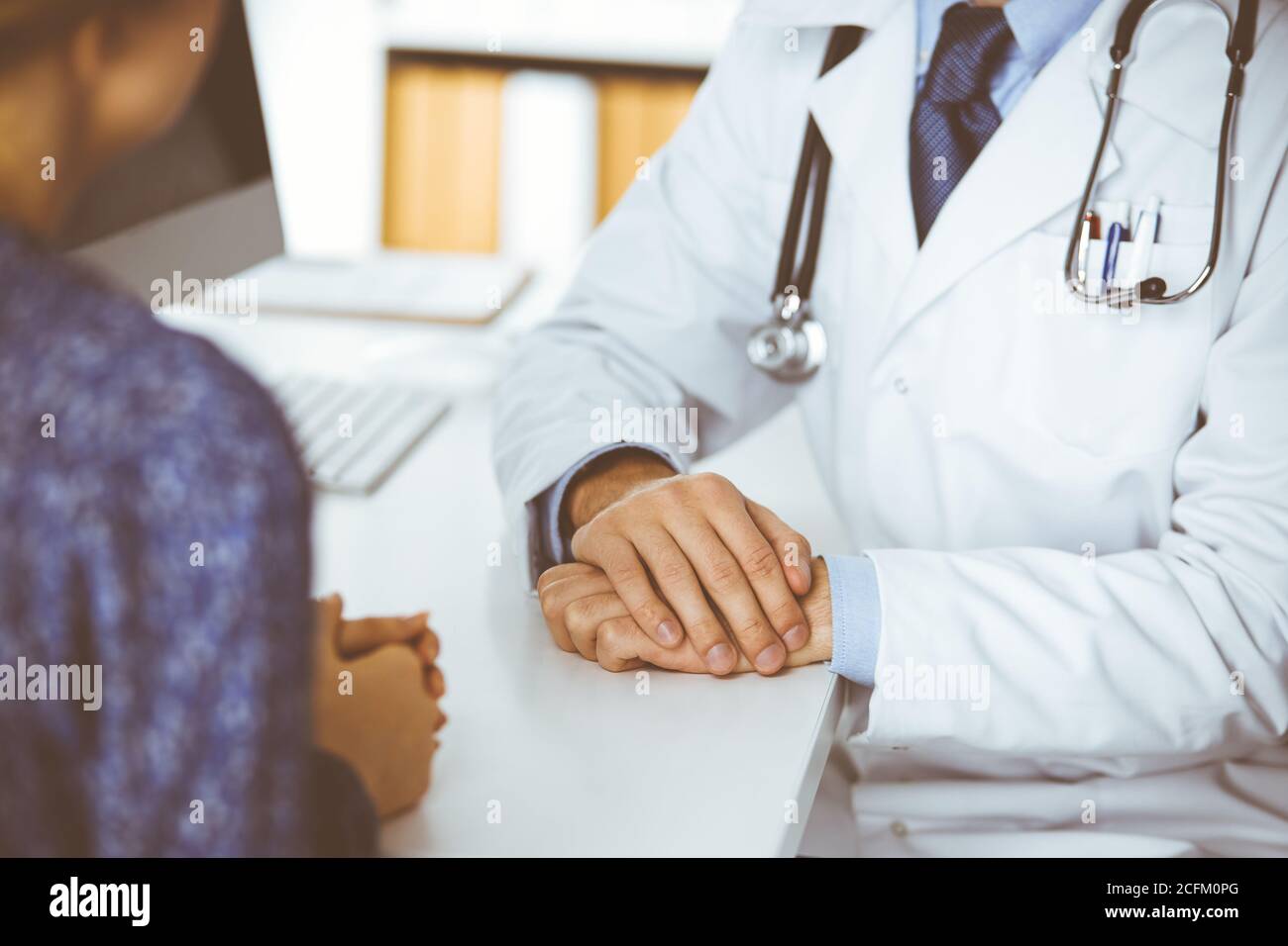Friendly red-beard doctor reassuring his female patient, close-up ...