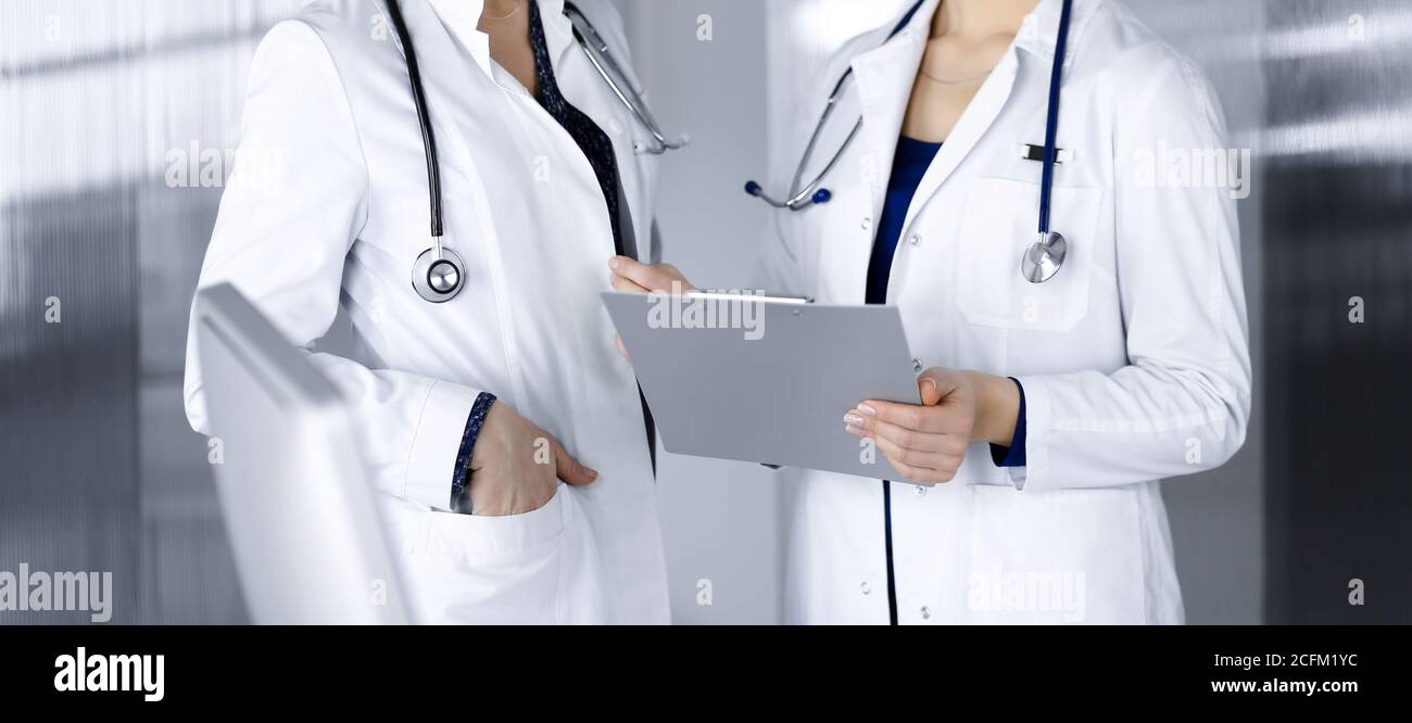 Two female physicians are discussing their patient's medical tests ...