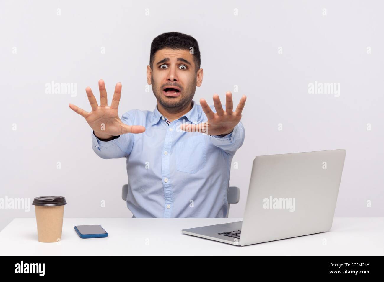 Scared man employee sitting office workplace with laptop on desk ...