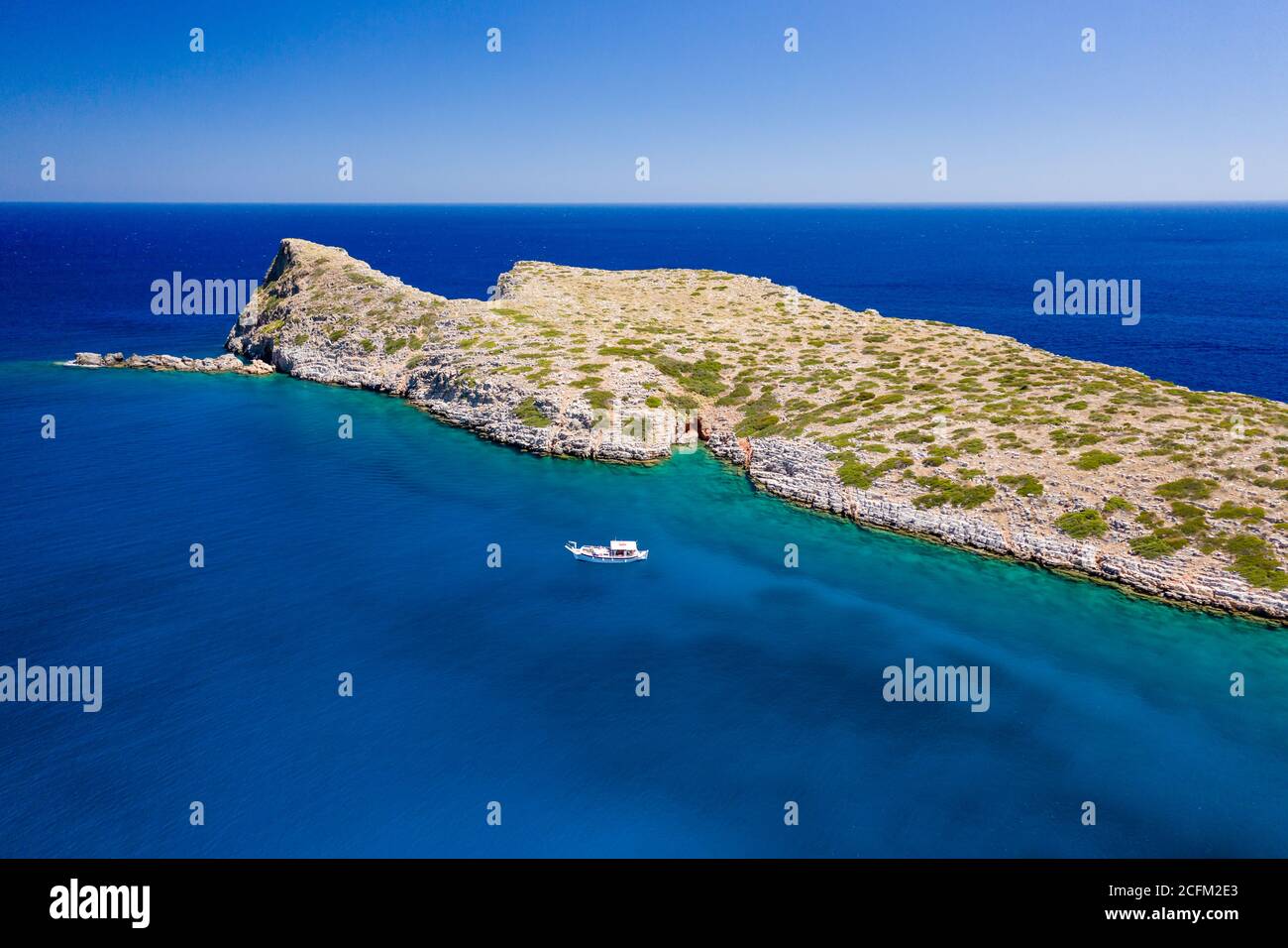 Aerial view of a small island and boats in a crystal clear blue ocean ...