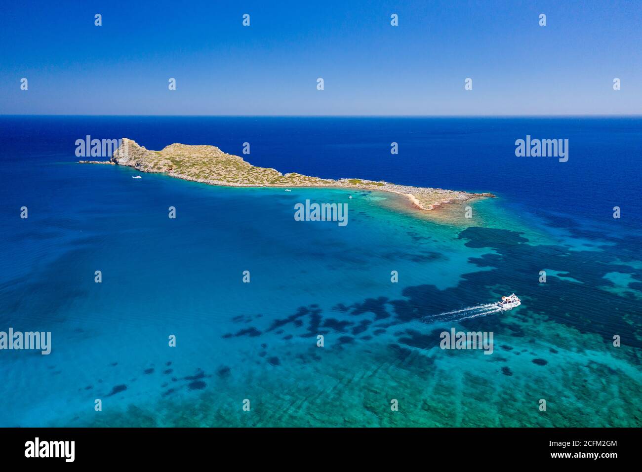 Aerial view of a small island and boats in a crystal clear blue ocean ...