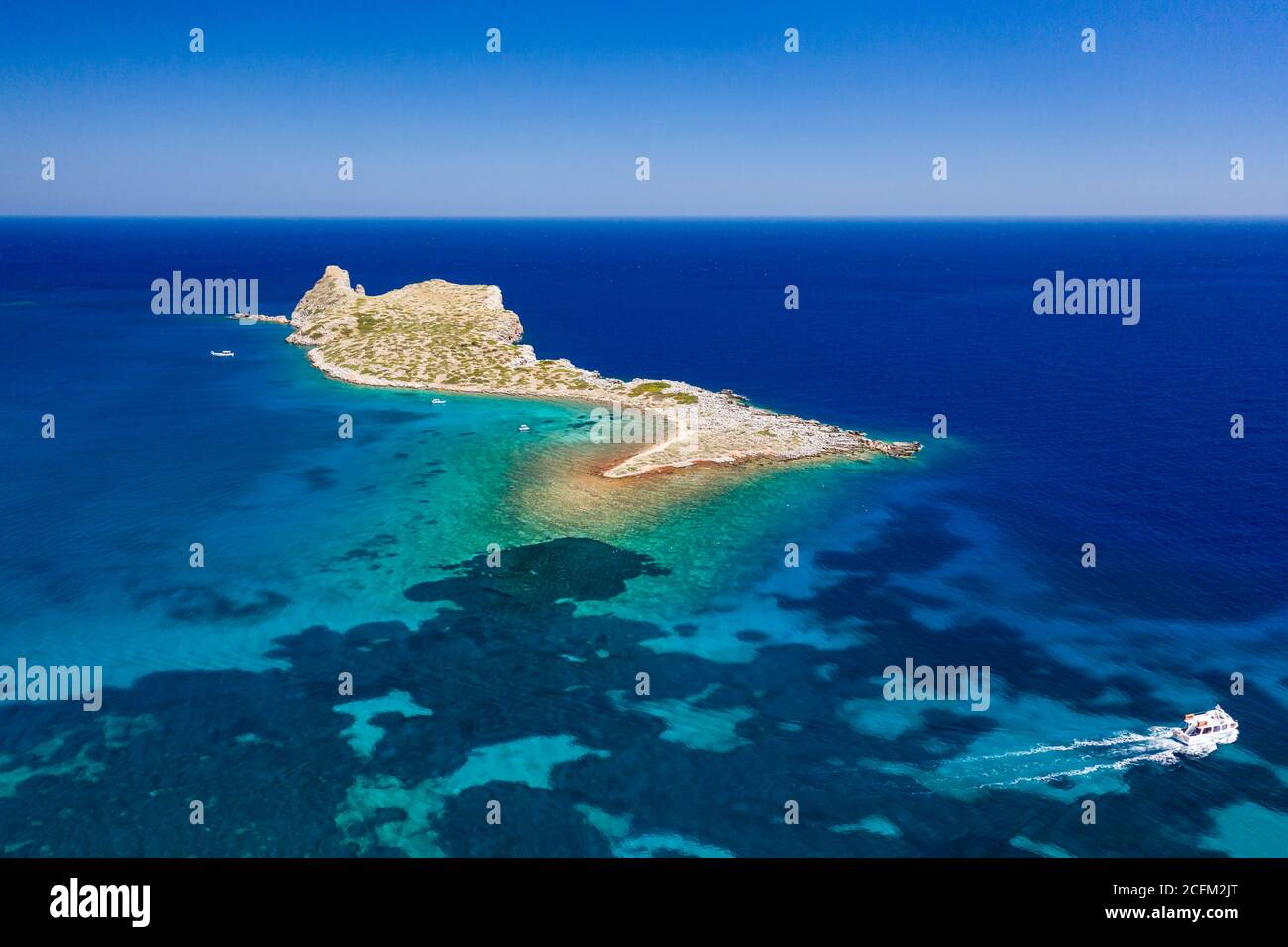 Aerial view of a small island and boats in a crystal clear blue ocean ...