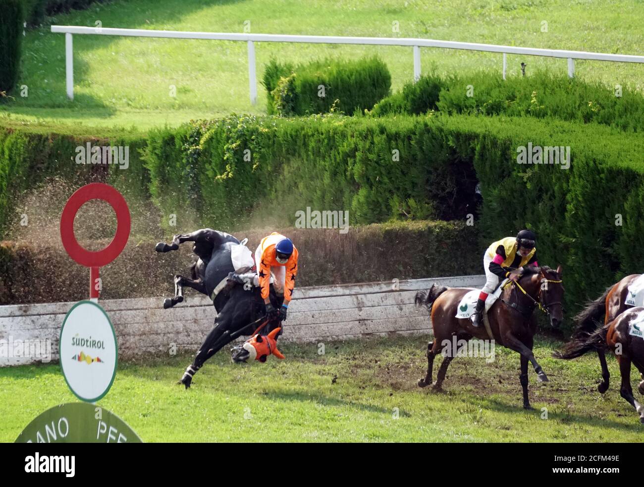 A jockey falling from a horse at the race while others running further ...
