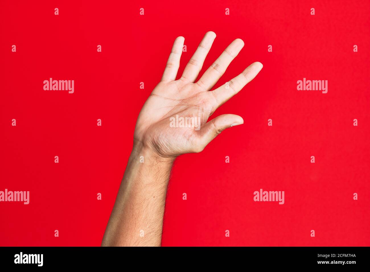 Arm of caucasian white young man over red isolated background ...