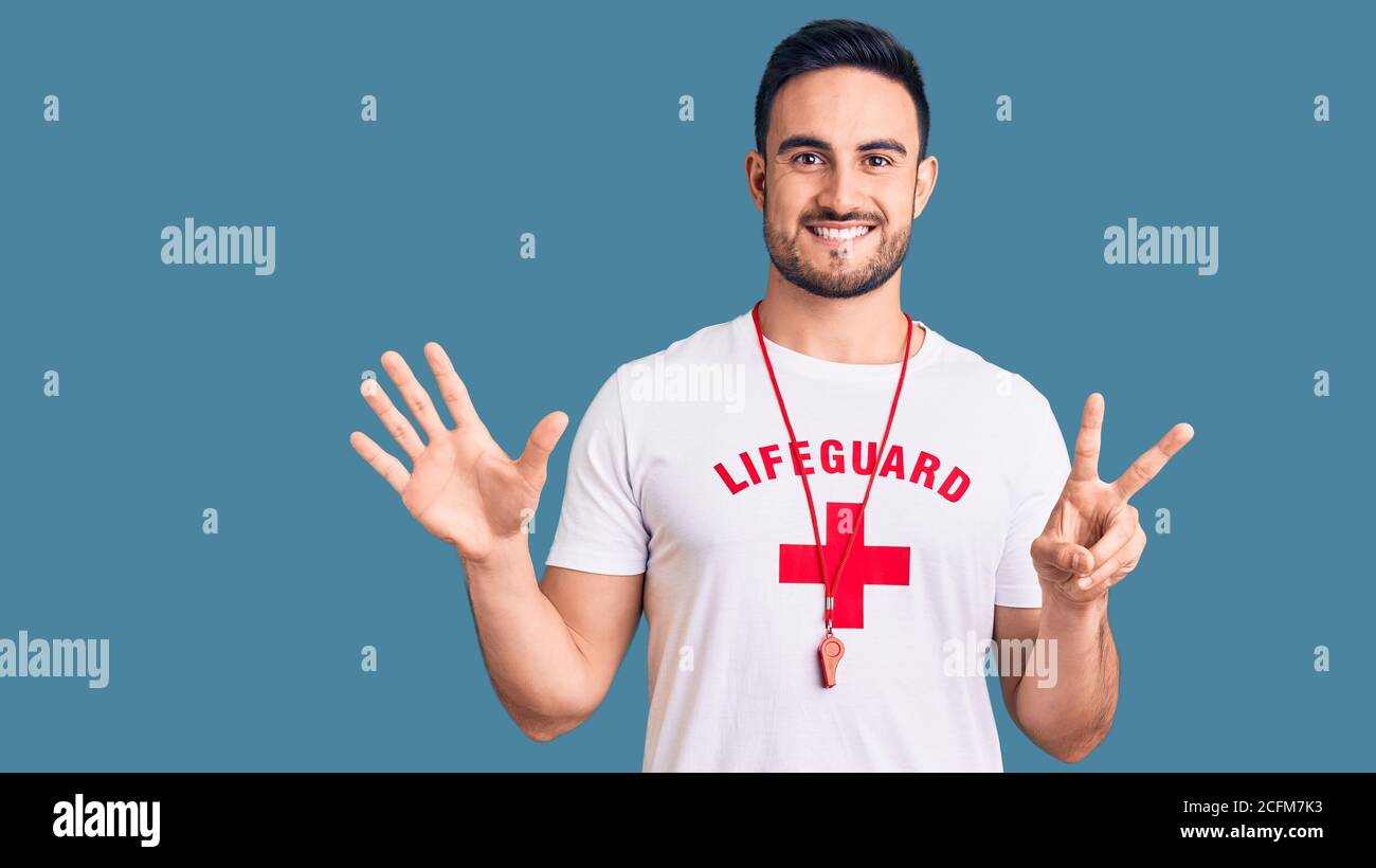 Young handsome man wearing lifeguard uniform showing and pointing up ...