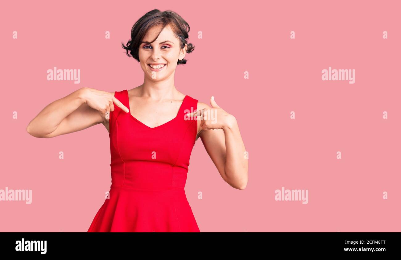 Beautiful young woman with short hair wearing casual style with sleeveless shirt looking ...