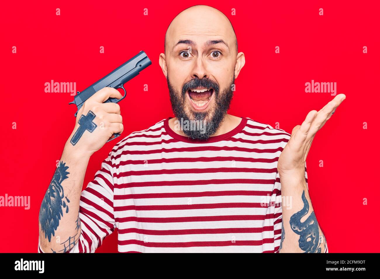 Young handsome man holding gun celebrating victory with happy smile and ...