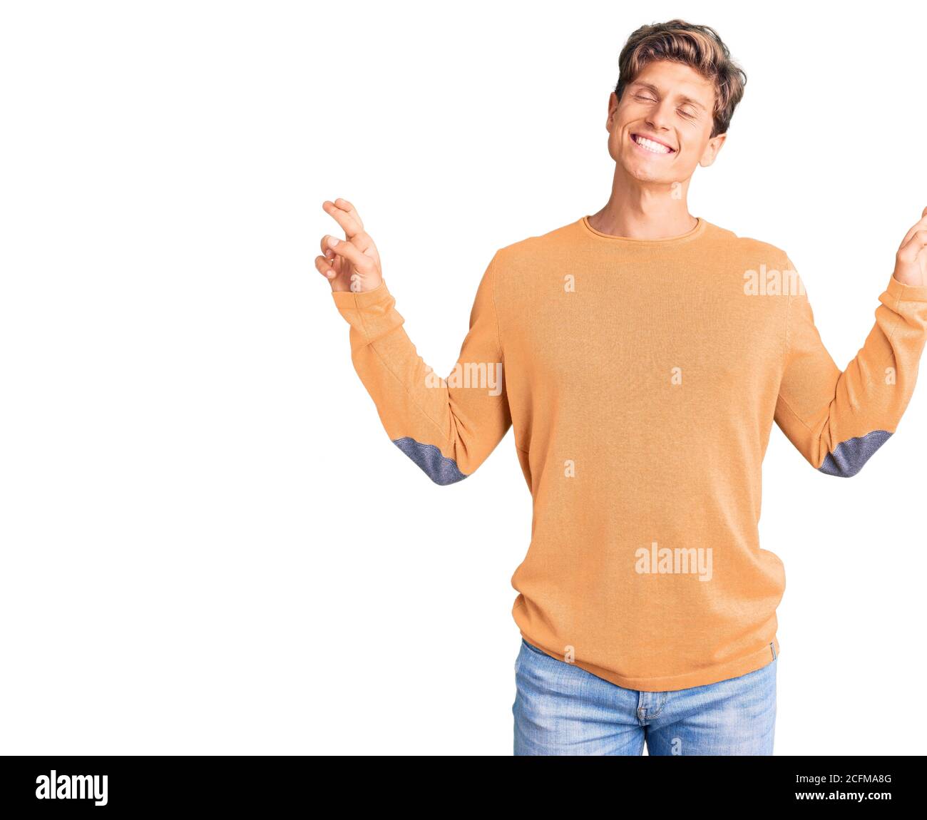 Hopeful young man crossing fingers Cut Out Stock Images & Pictures - Alamy