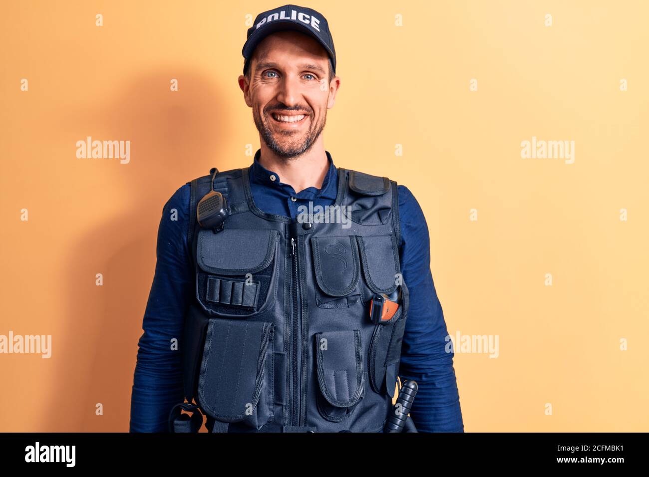 Young handsome policeman wearing police uniform and bulletprof over ...