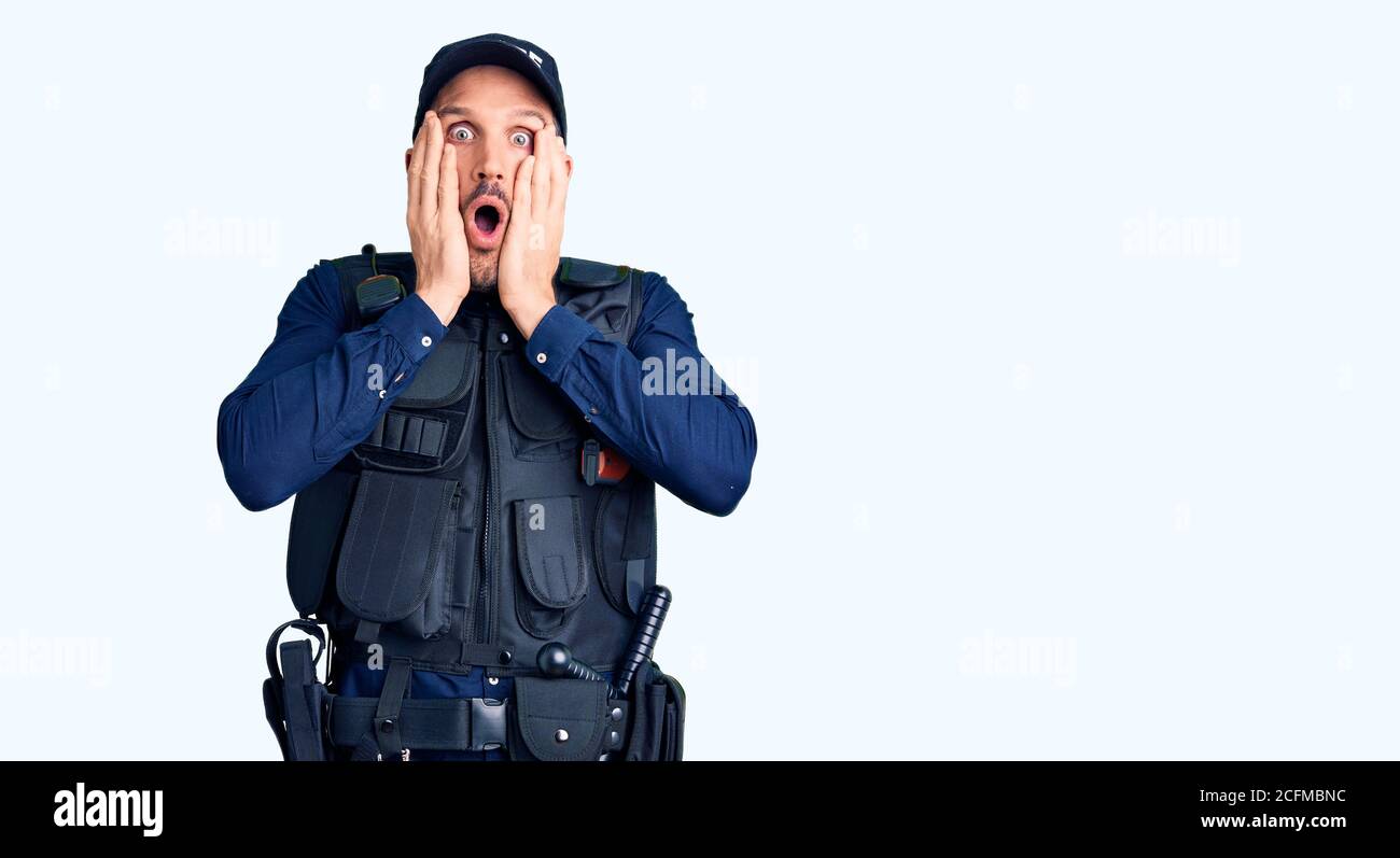 Young handsome man wearing police uniform afraid and shocked, surprise ...