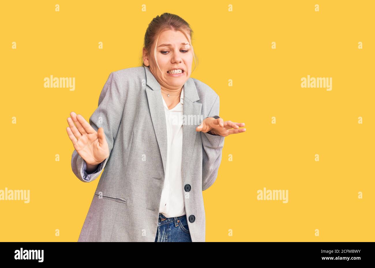 Young beautiful blonde woman wearing elegant jacket disgusted ...