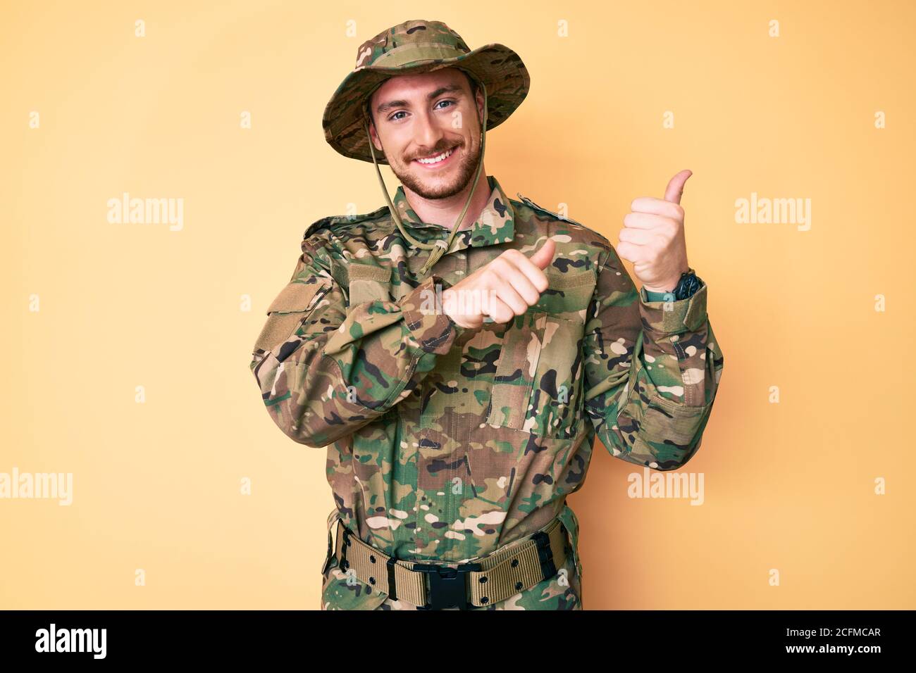 Young caucasian man wearing camouflage army uniform pointing to the ...
