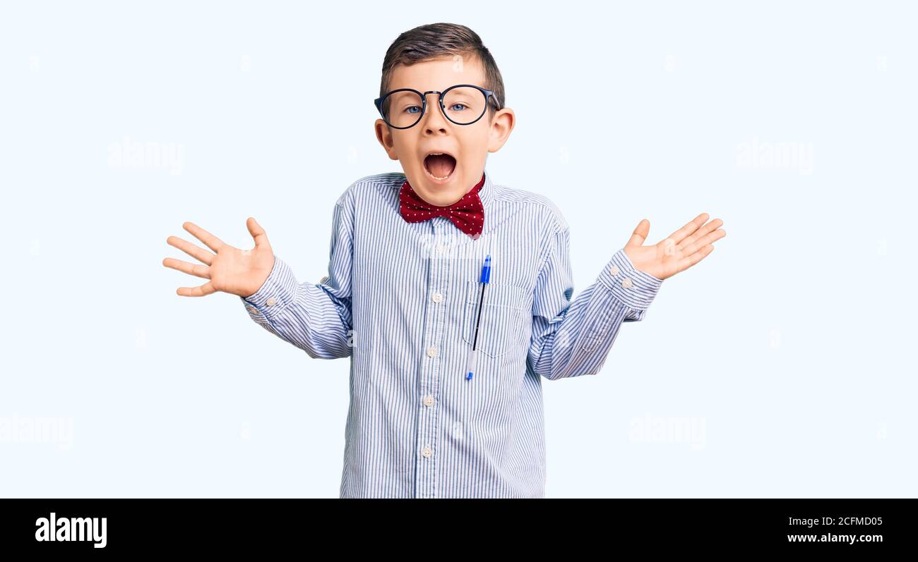 Cute blond kid wearing nerd bow tie and glasses celebrating victory ...