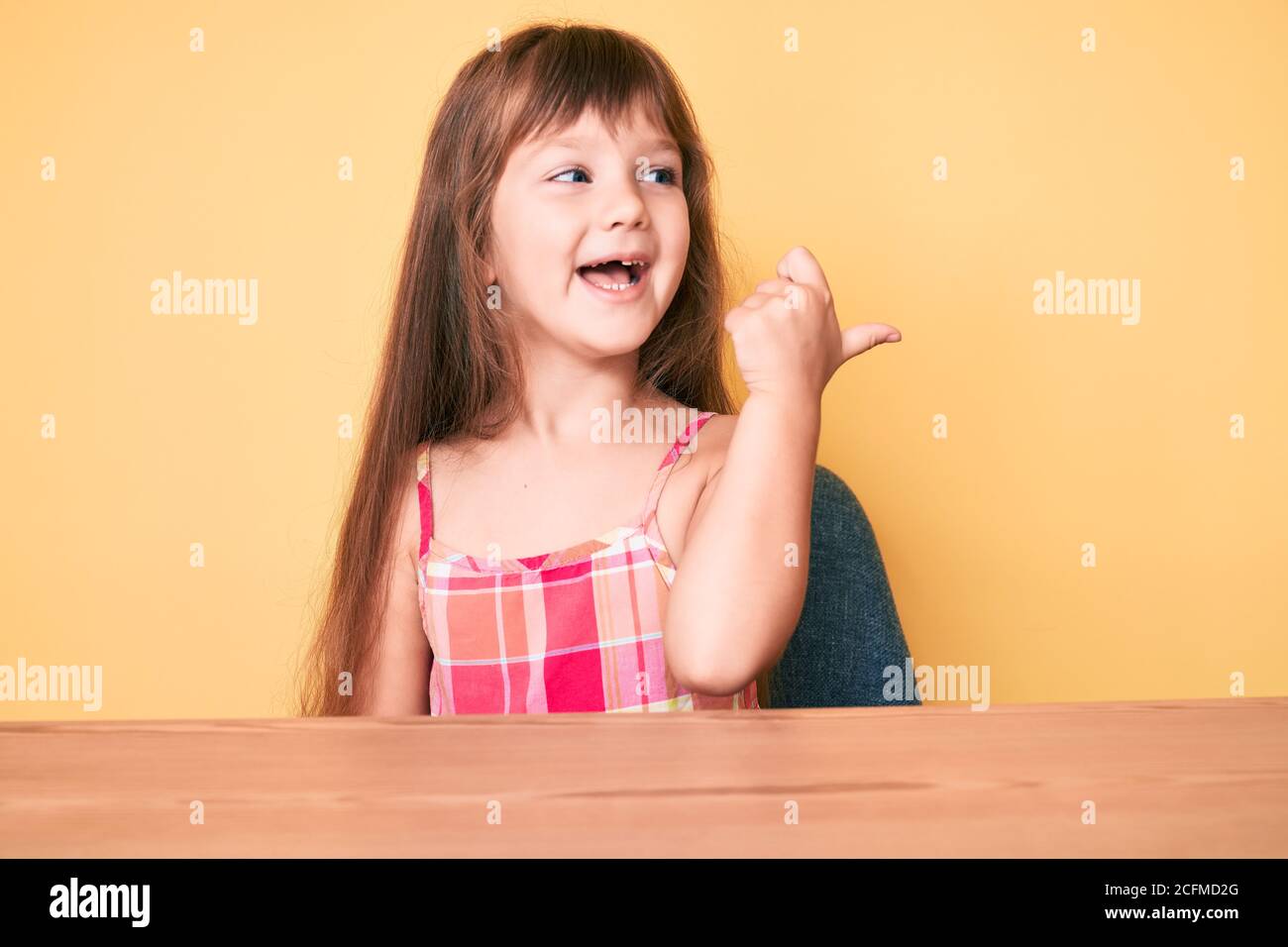 Little caucasian kid girl with long hair wearing casual clothes sitting ...