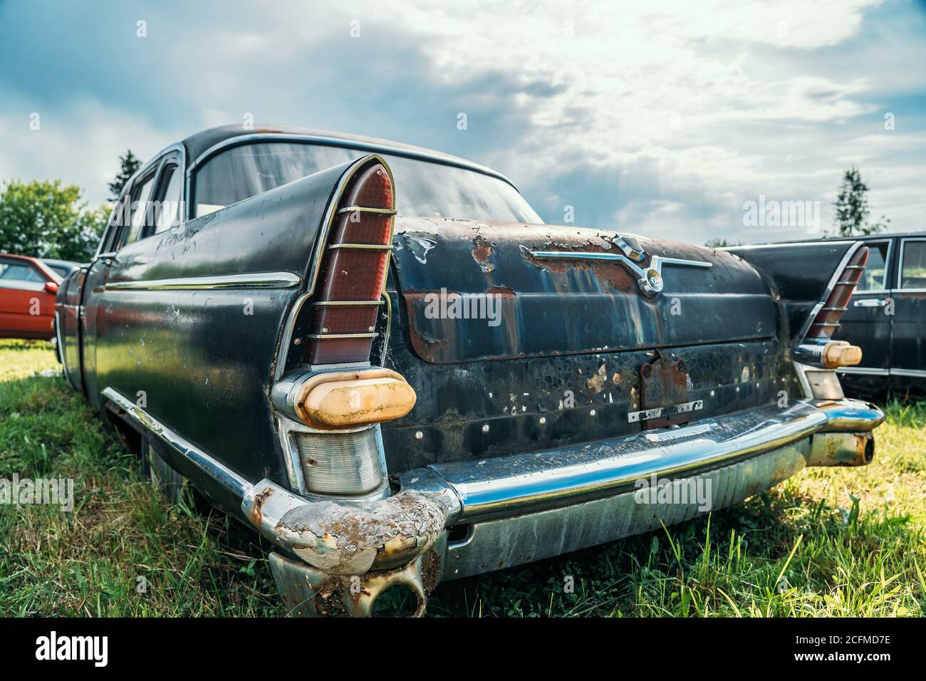 Old abandoned rusty car rusting on green grass Stock Photo - Alamy