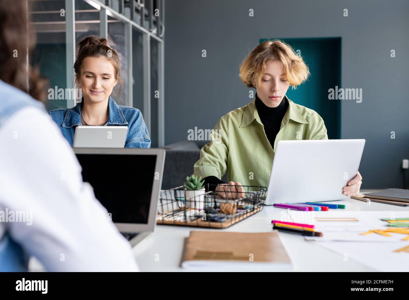 Two young creative female programmers working over new software in ...