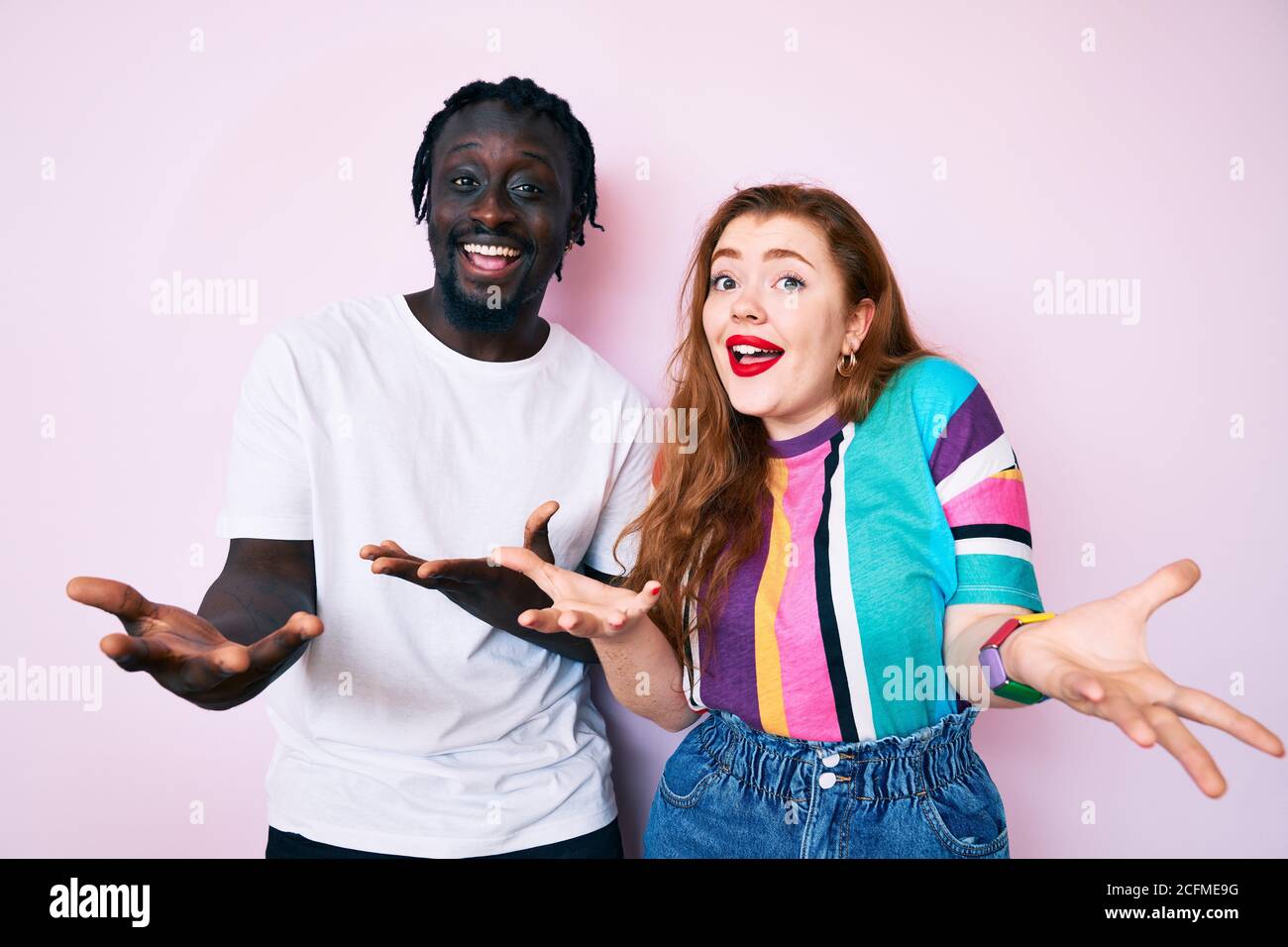 Interracial couple wearing casual clothes smiling cheerful with open ...