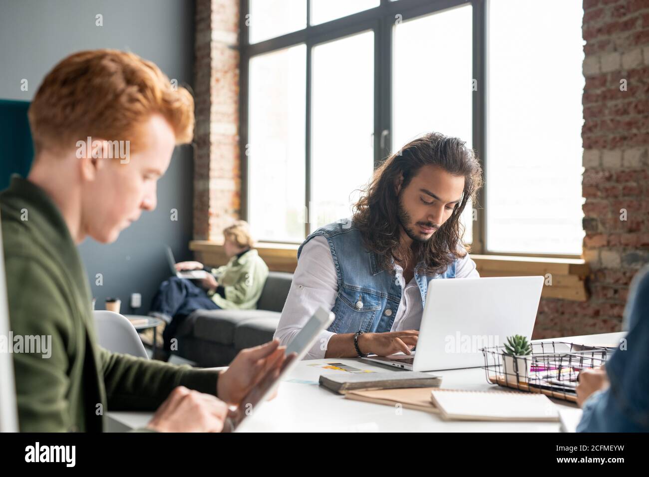 Young male developer of software working in front of laptop among co ...