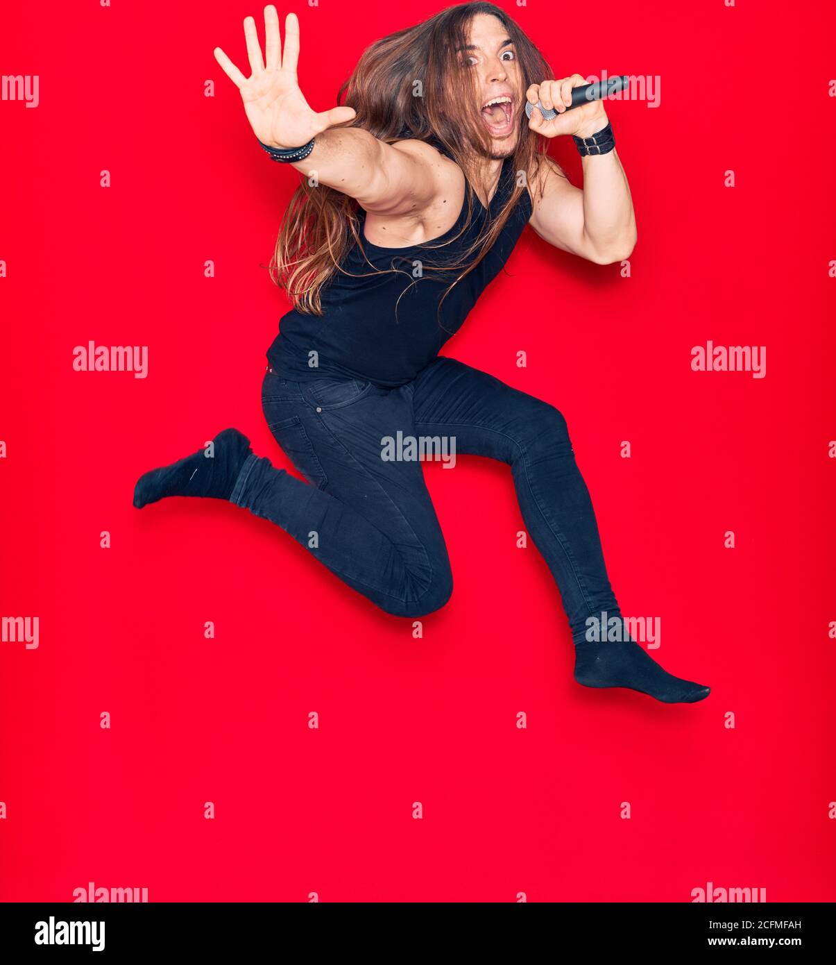 Young handsome heavy metal singer man with long hair and aggressive ...